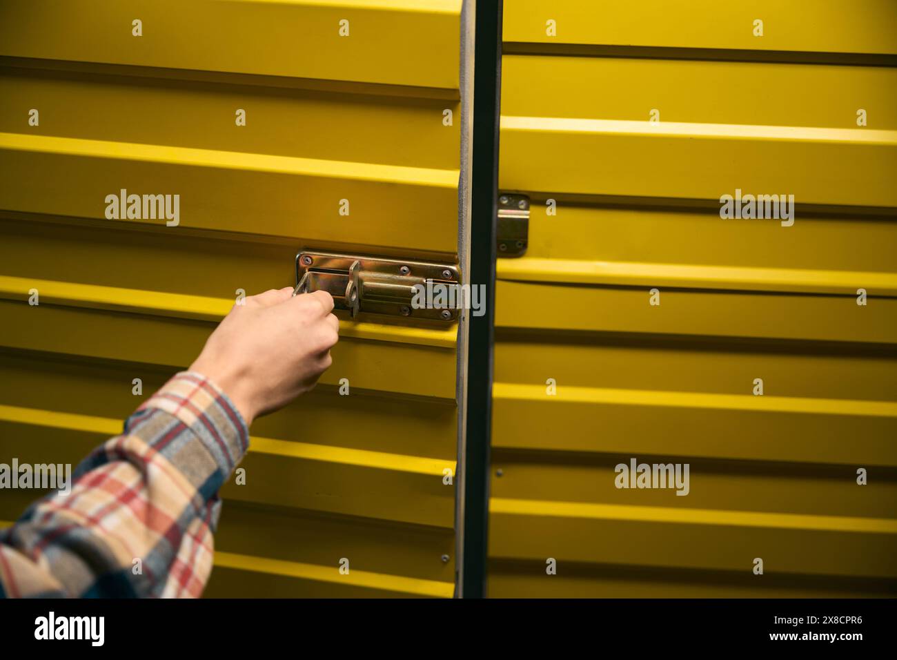 Warehouse employee is closing metal storage unit door Stock Photo - Alamy