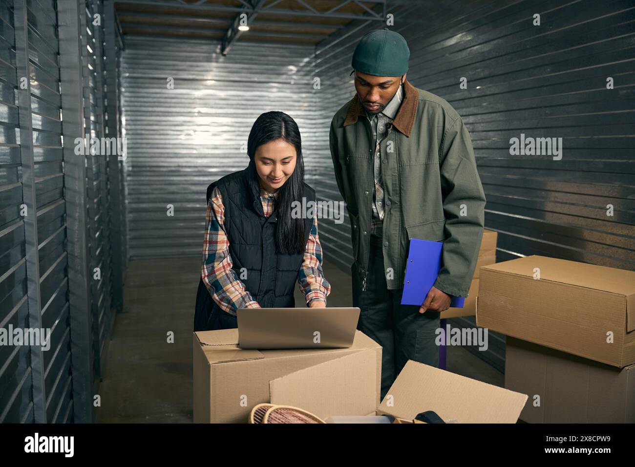 Two people working together in storage unit Stock Photo - Alamy