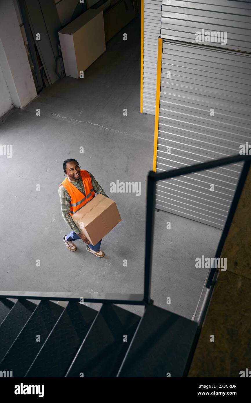 Joyous young freight handler working in modern storage facility Stock ...