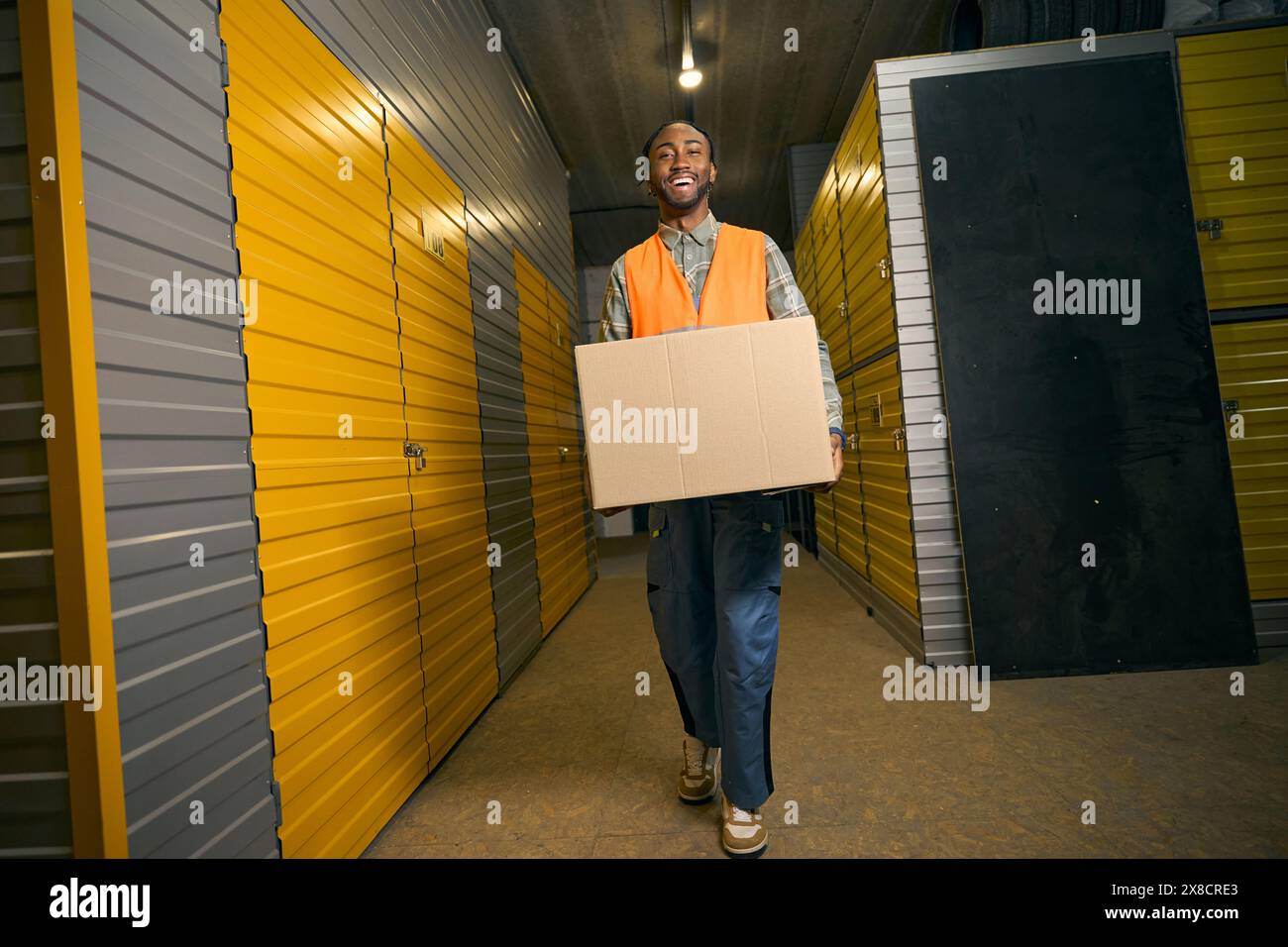 Merry cargo handler working in modern warehouse Stock Photo - Alamy