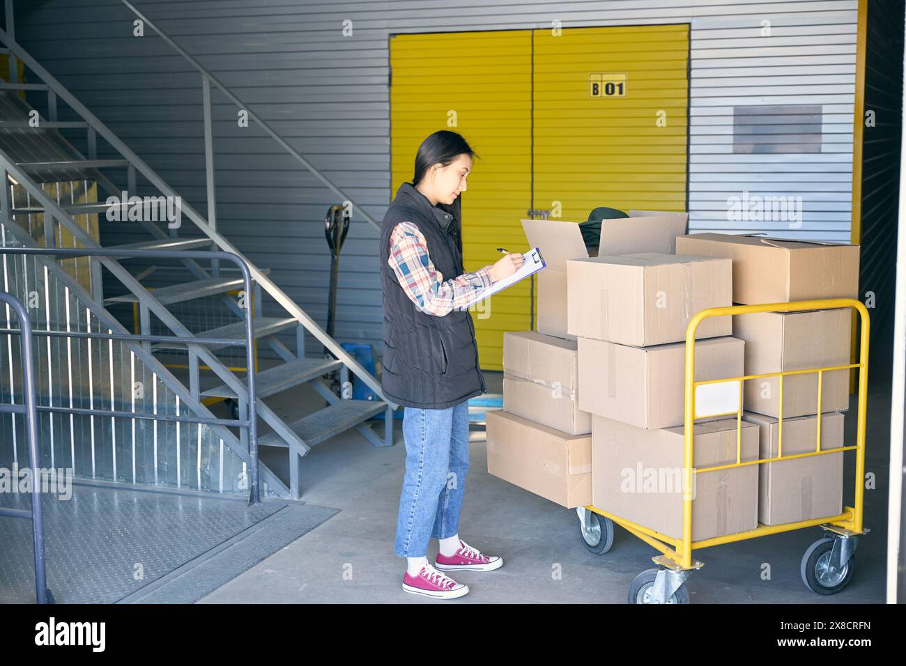 Focused warehouse worker involved in freight handling Stock Photo - Alamy