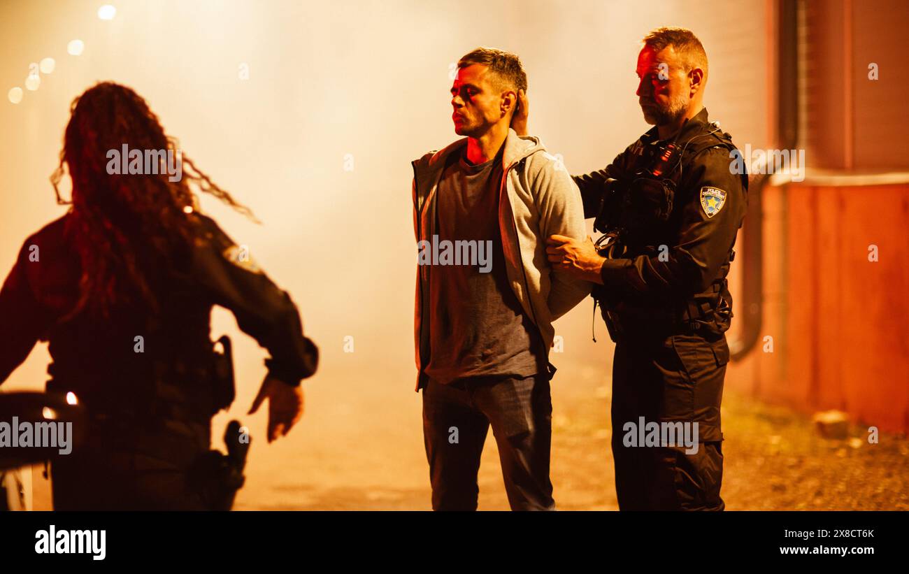 Two Police Officers Arresting a Criminal During Night and Putting Him ...