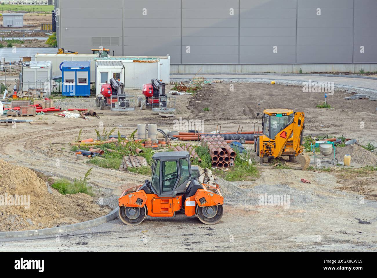 Road Roller and Backhoe Digger at Construction Site New Factory ...