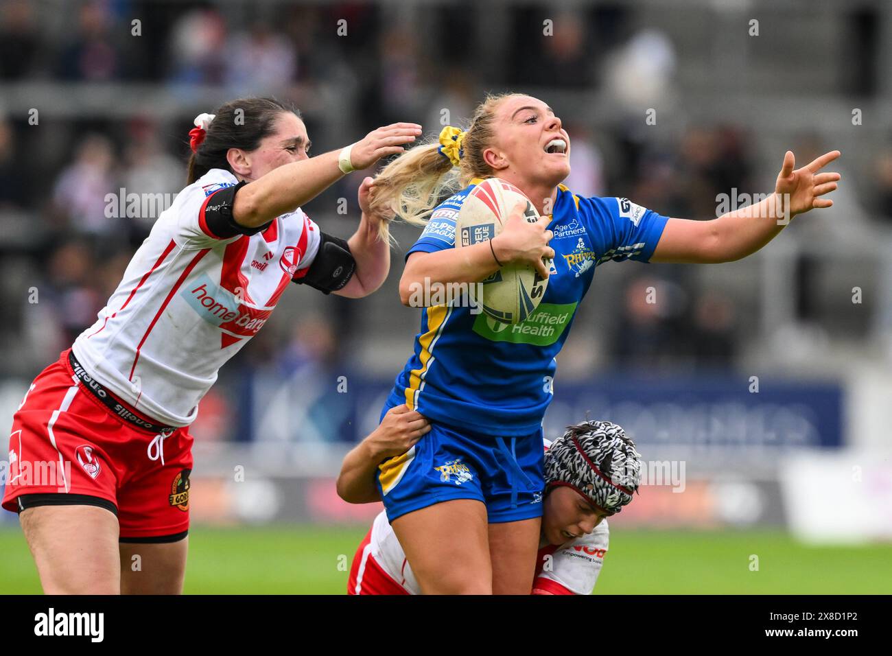 Lucy Murray of Leeds Rhinos has her hair pulled by Faye Gaskin of St ...