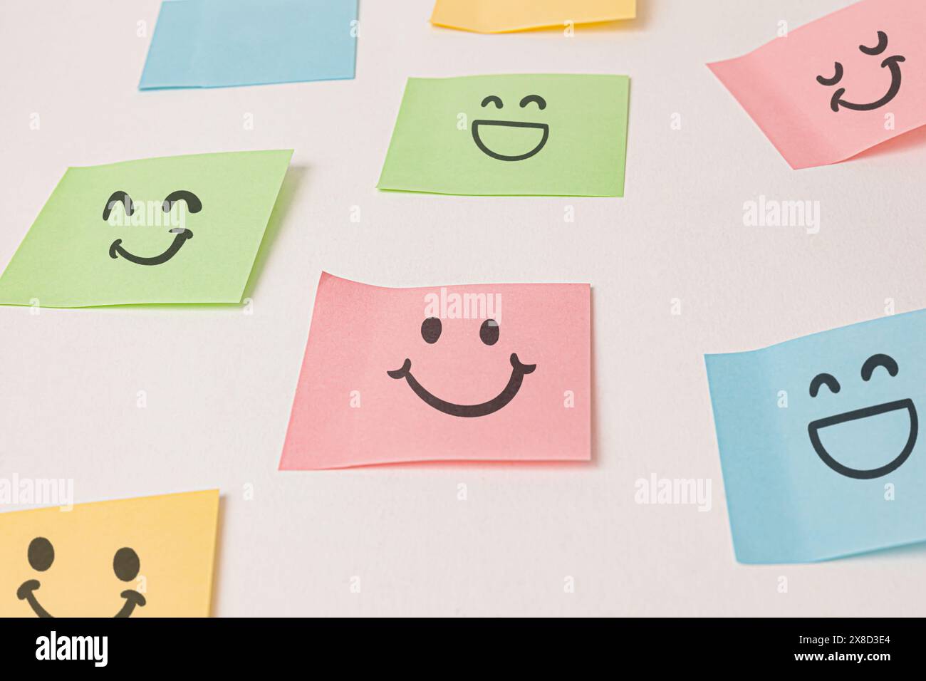 Colorful sticker notes with smiley face on white wall Stock Photo - Alamy