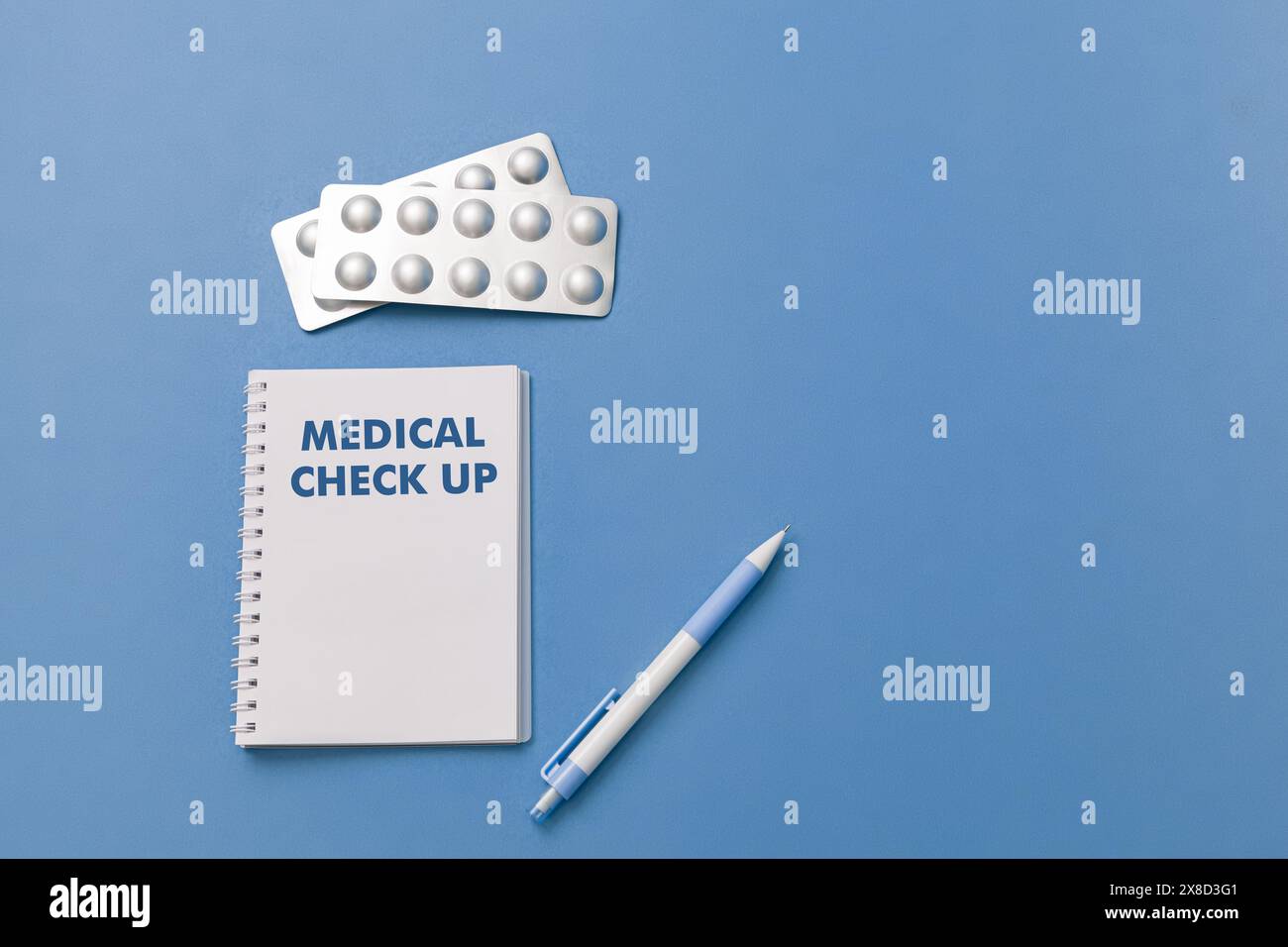 Medical check up concept on blue background: Notebook, medicine, pen ...
