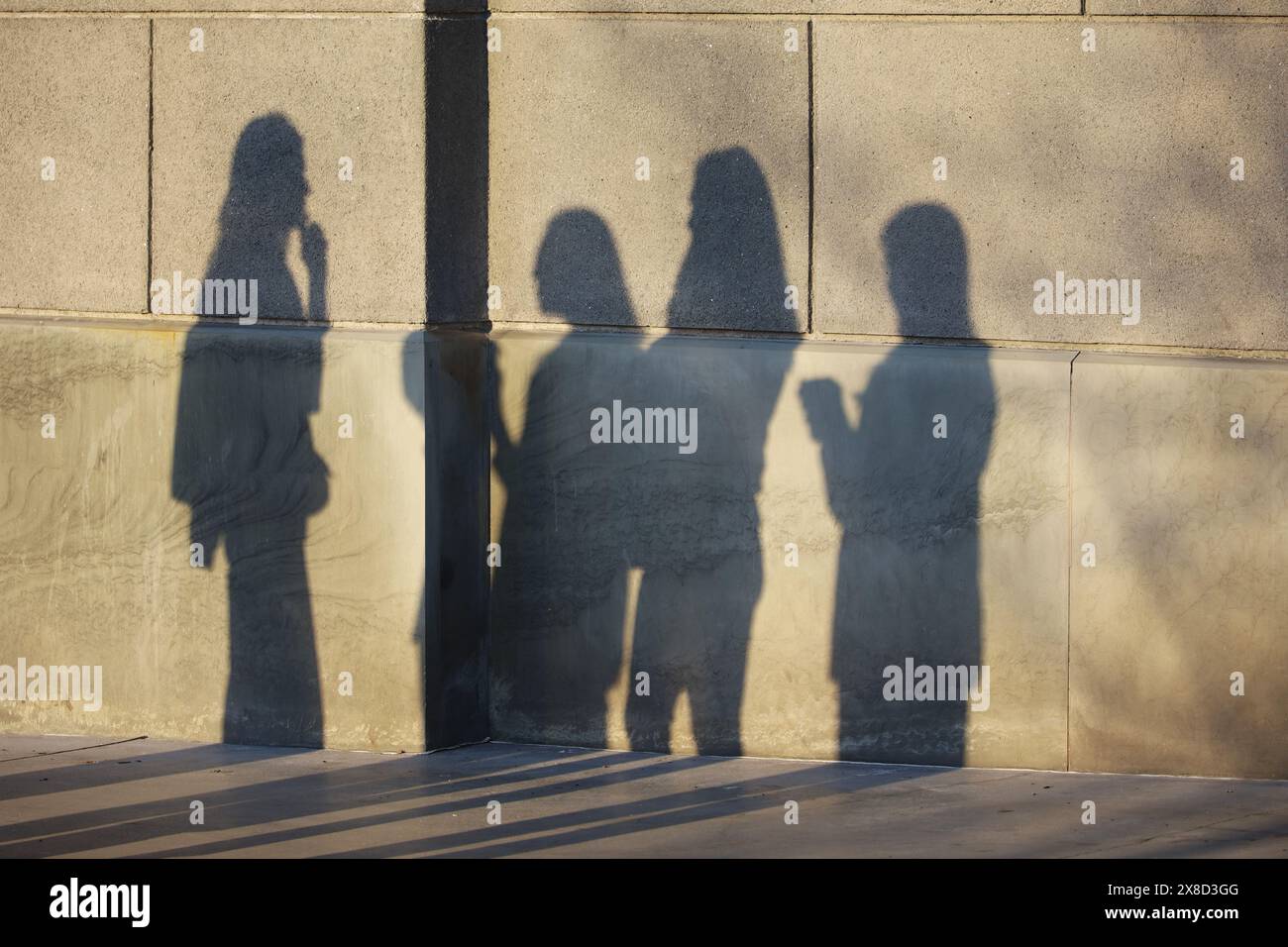Shadows of people on building wall. Group of women talking on city ...