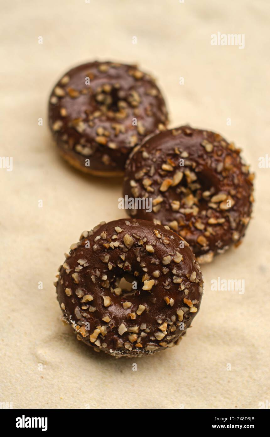 Three chocolate donut with sprinkles on beige background . High quality ...