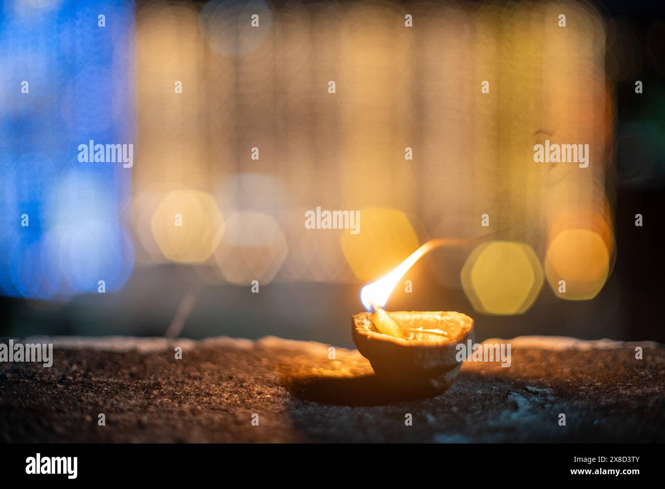 macro shot showing a circle of diya oil lamps around a rupee coin ...