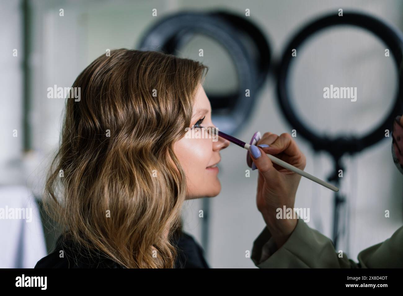Backstage of the photo shoot: Make-up artist applies makeup on ...