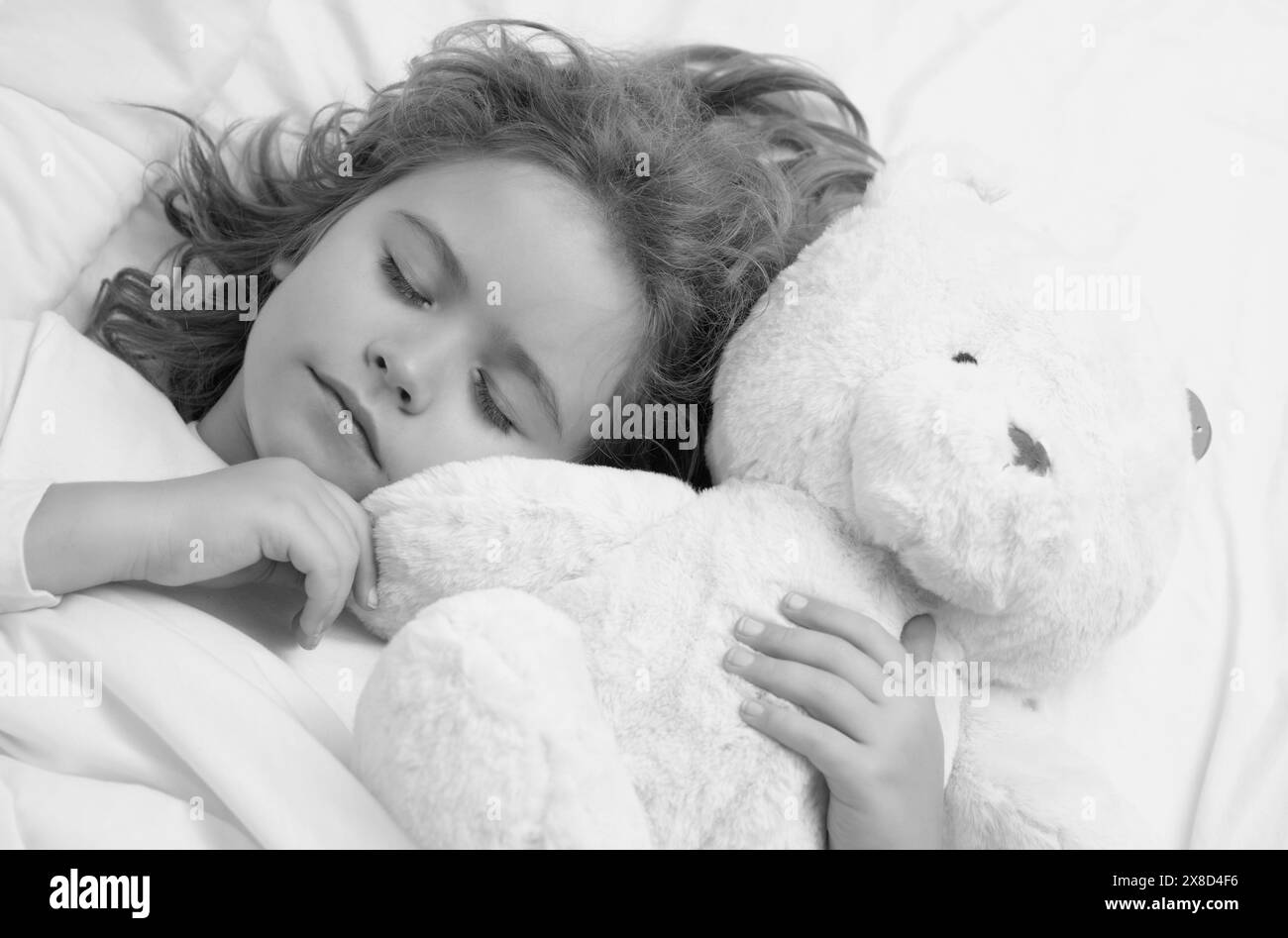 Daily sleep. Cute kid sleeps with a toy teddy bear in bed. Sleeping ...