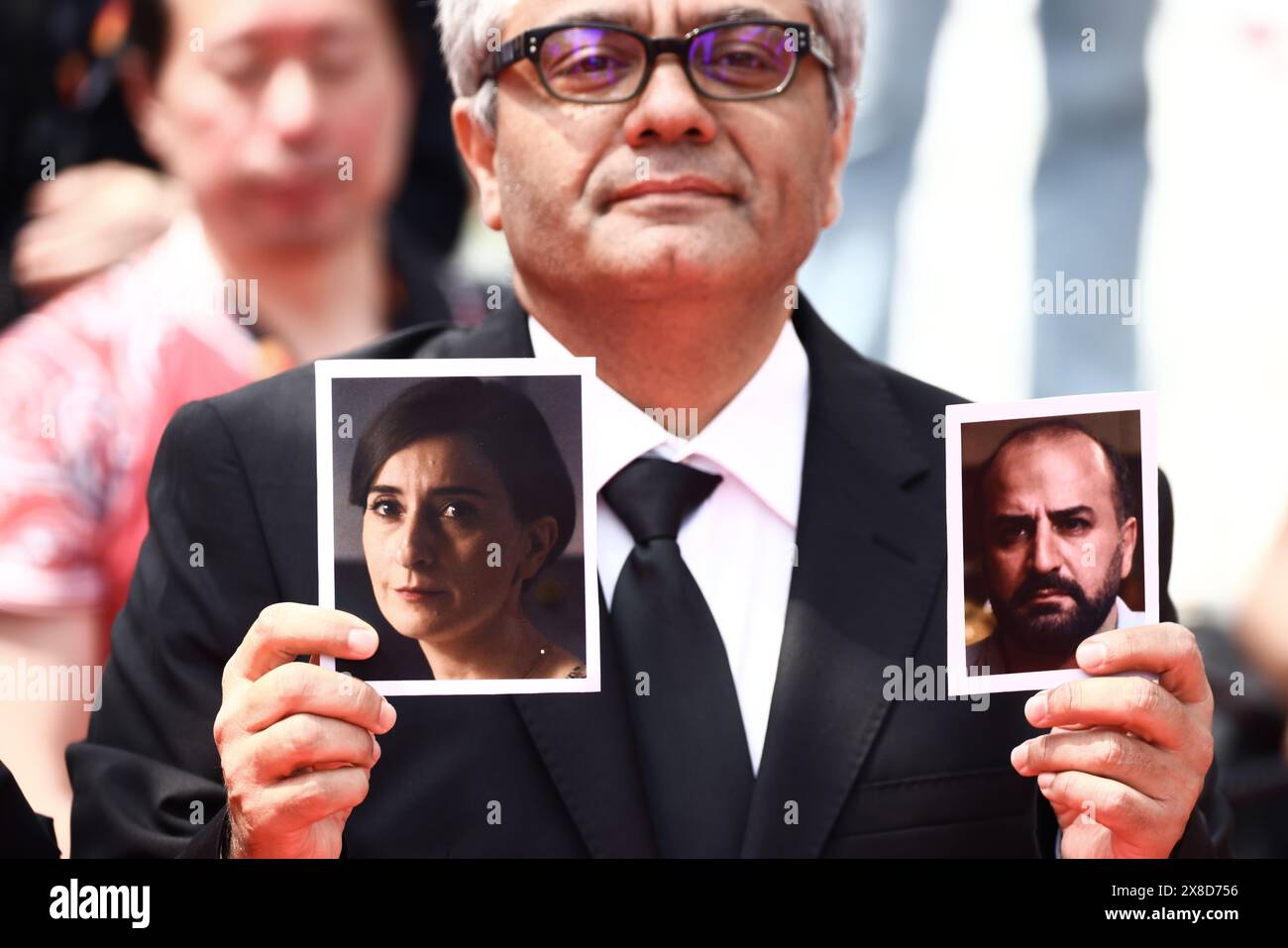 Cannes, France. 24th May, 2024. Mohammad Rasoulof holds portraits of ...