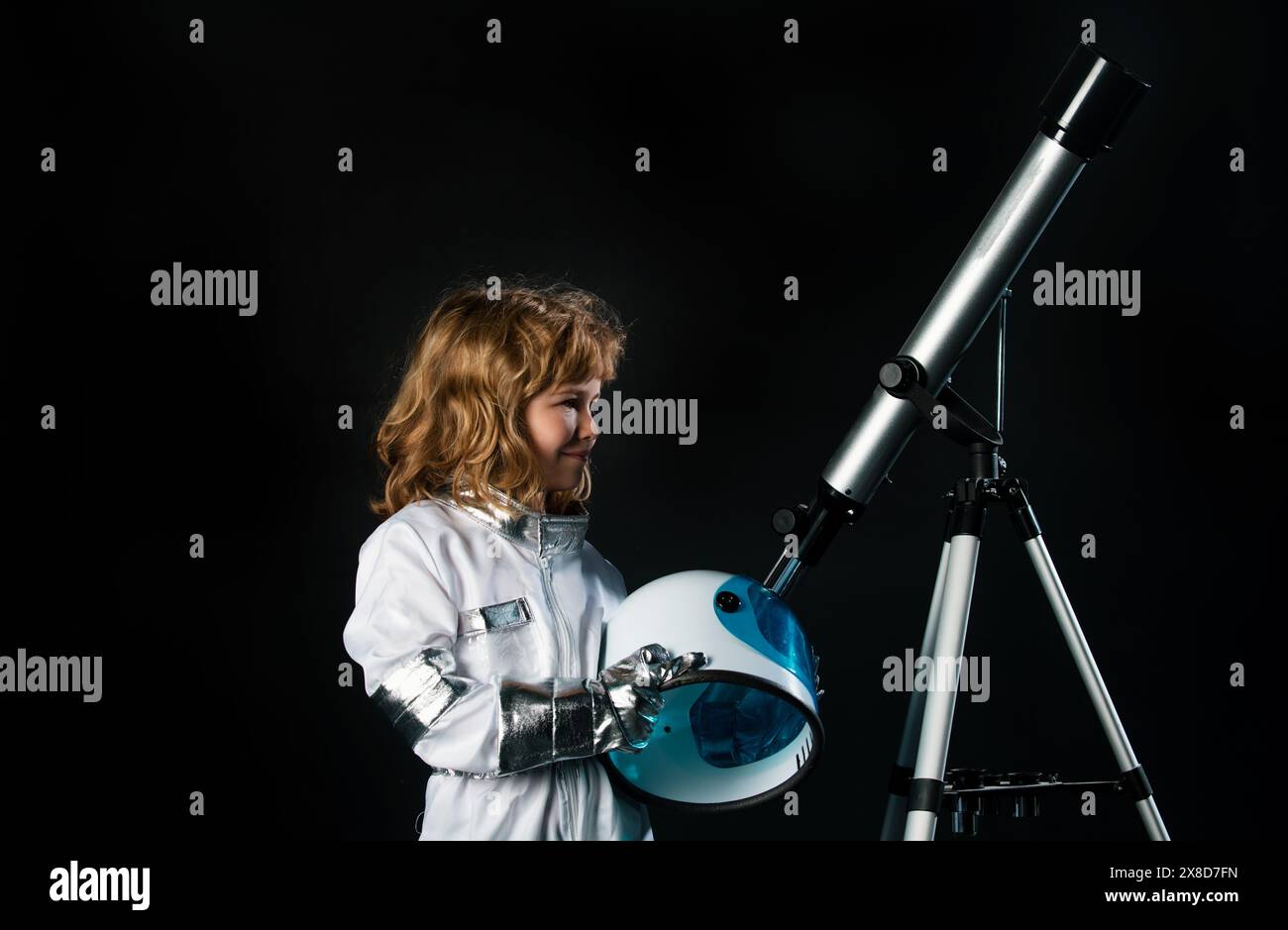 Portrait of wondered little astronaut in helmet and protective space ...