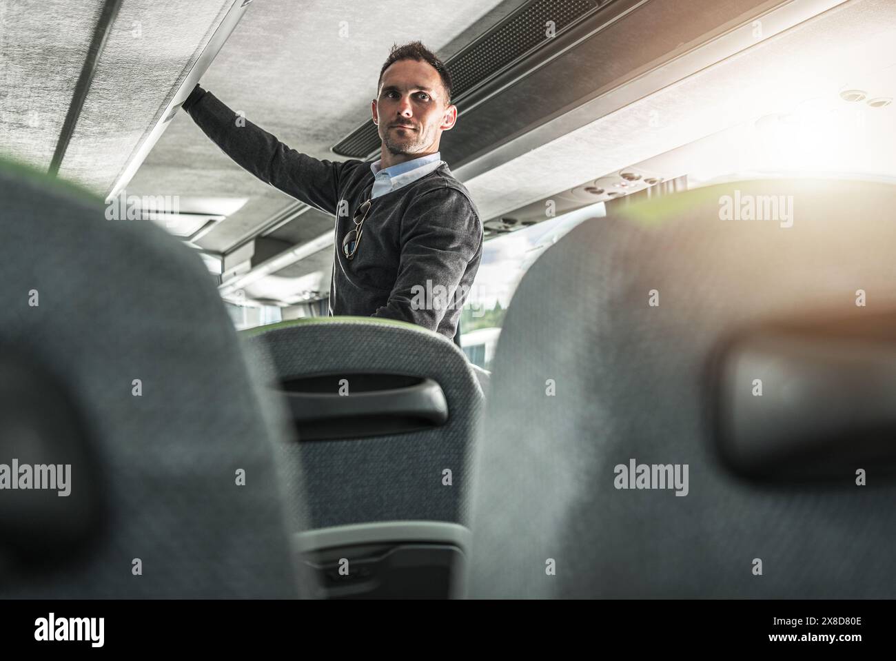 A man standing inside a bus with his arm extended to lugged cargo ...
