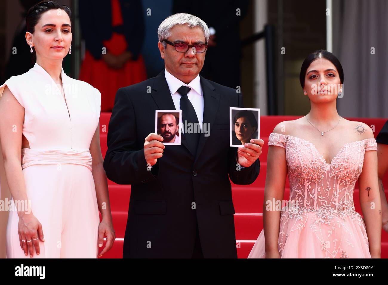 Cannes, France. 24th May, 2024. Mohammad Rasoulof holds portraits of ...