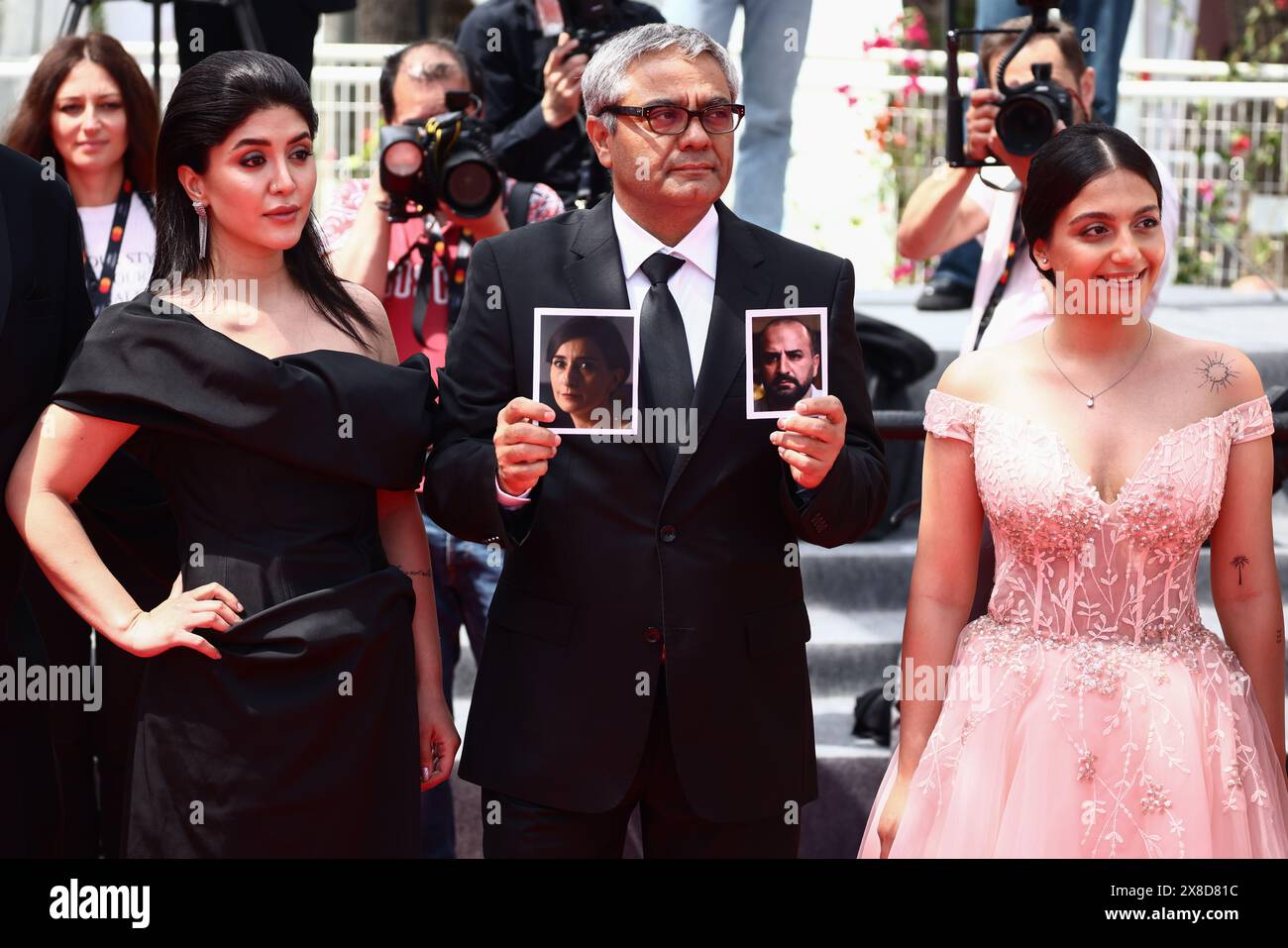 Cannes, France. 24th May, 2024. Mohammad Rasoulof holds portraits of ...