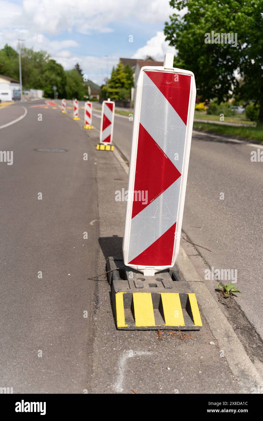 Row of reflective traffic diversion signs in red and white with yellow ...
