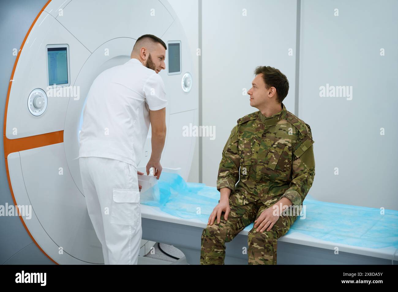 Doctor preparing military patient for magnetic resonance imaging ...