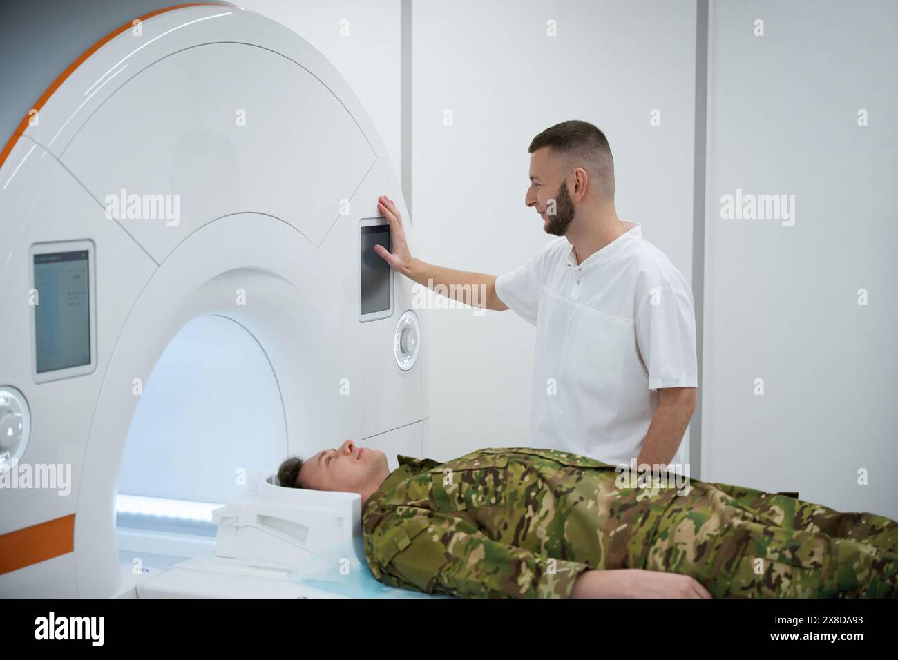 Medical professional preparing military man for magnetic resonance ...