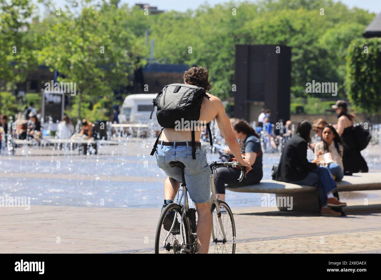 Cycling past the fountains on Granary Square on a sunny early spring ...