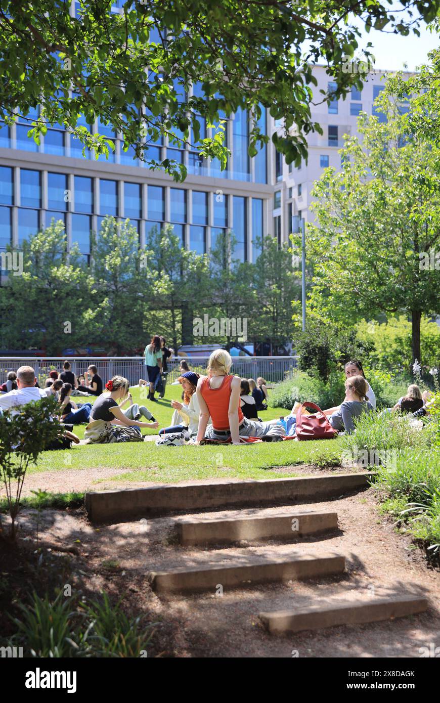 Workers relaxing in Wharf Gardens by Granary Square, in late spring ...