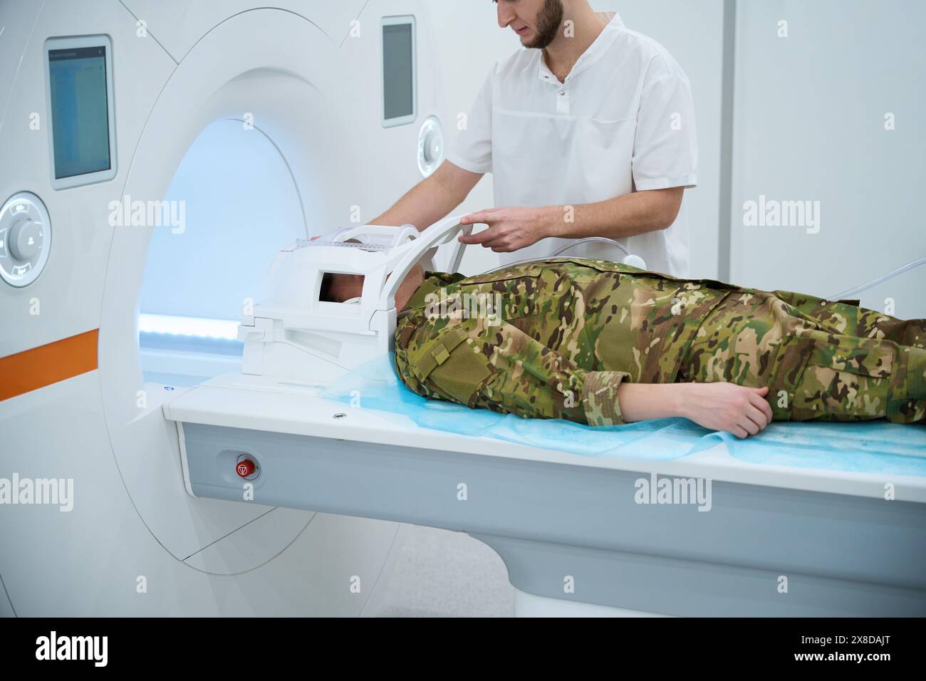 Doctor preparing serviceperson for brain magnetic resonance imaging ...