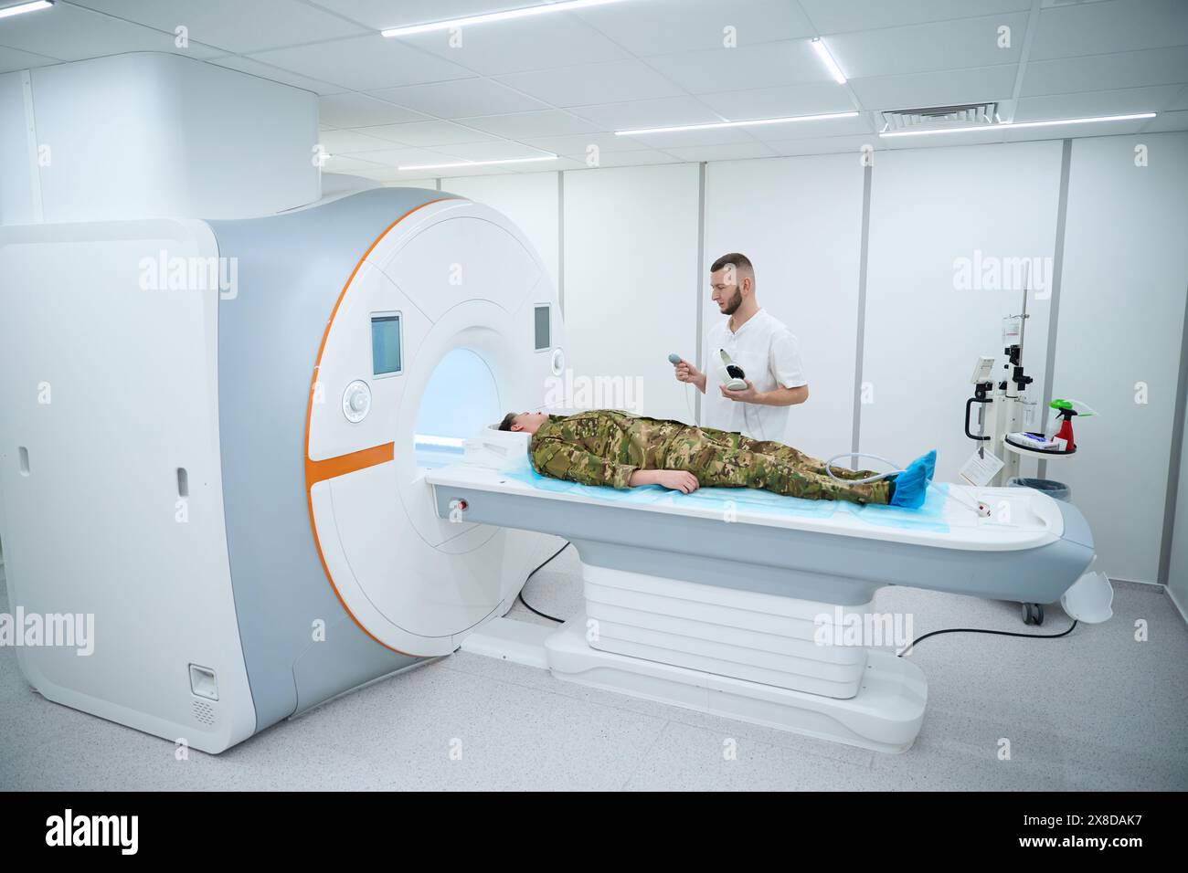 Serious radiographer preparing military man for magnetic resonance ...