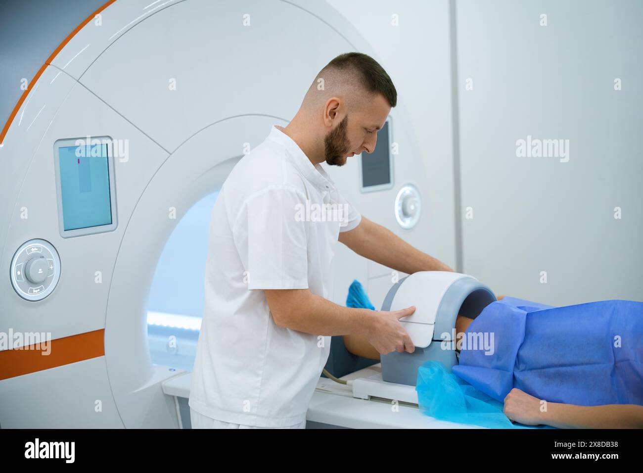 Radiographer preparing patient for MRI of lower extremity joint Stock ...