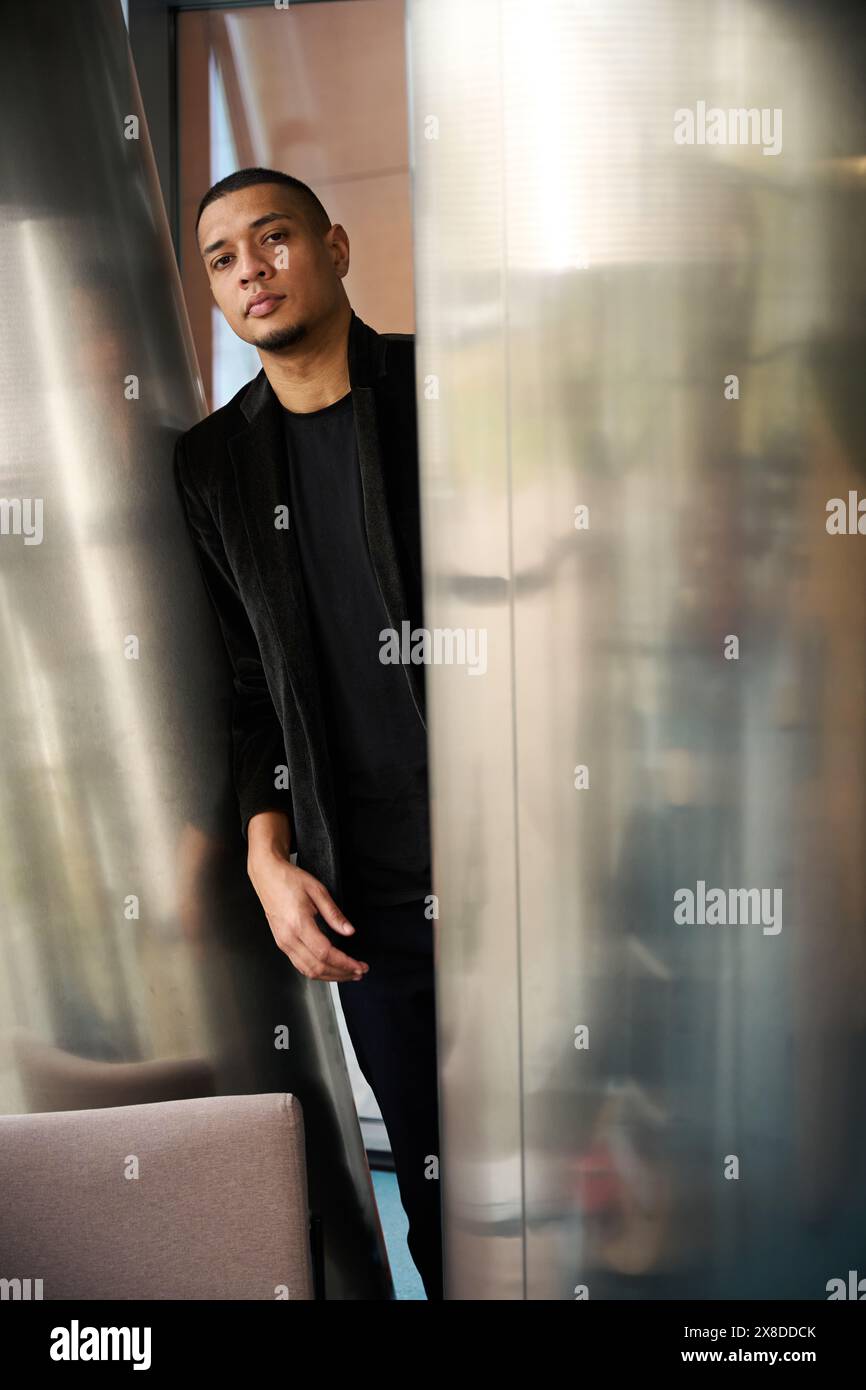 Serious guy standing between two steel poles Stock Photo - Alamy