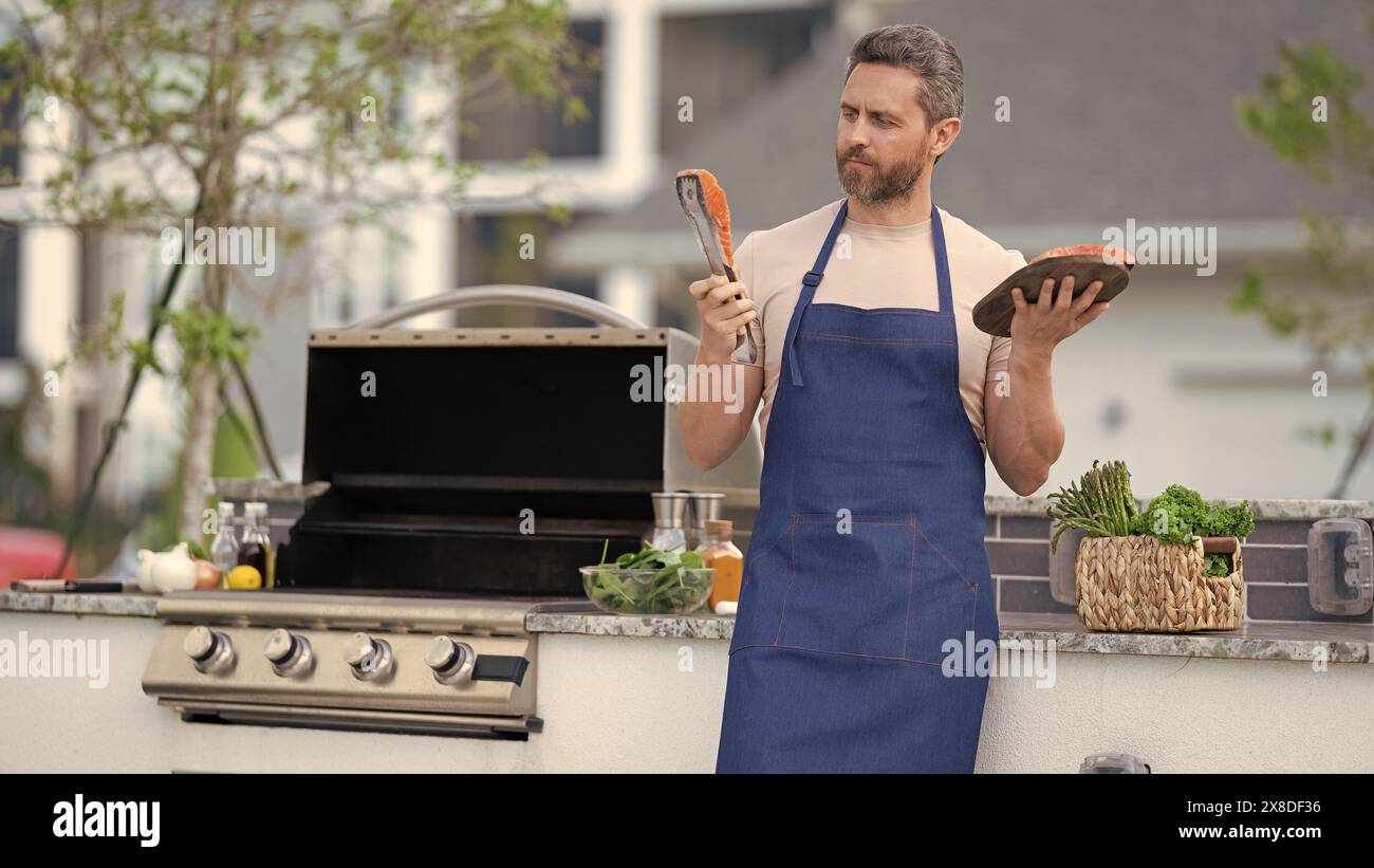 photo of chef with grilled salmon, copy space banner. chef with grilled ...