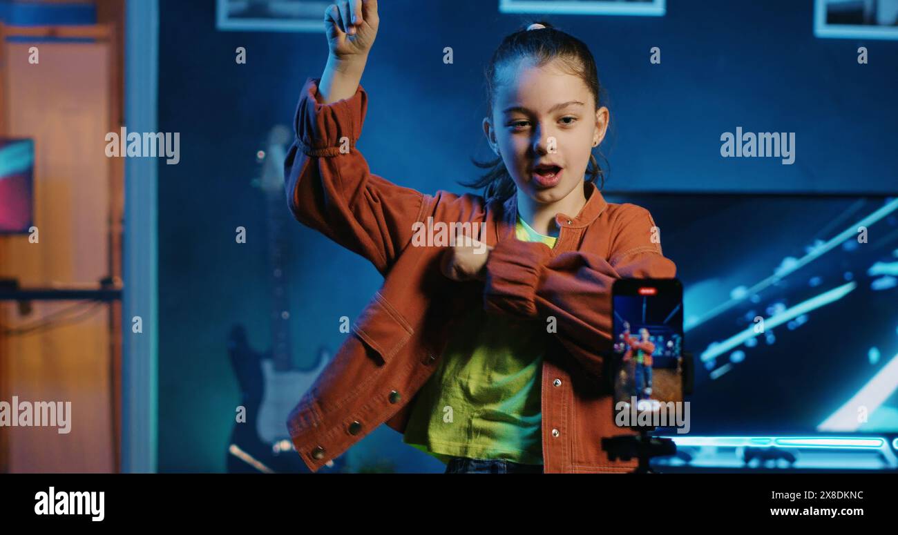 Children influencer dancing in home studio, recording video with mobile ...
