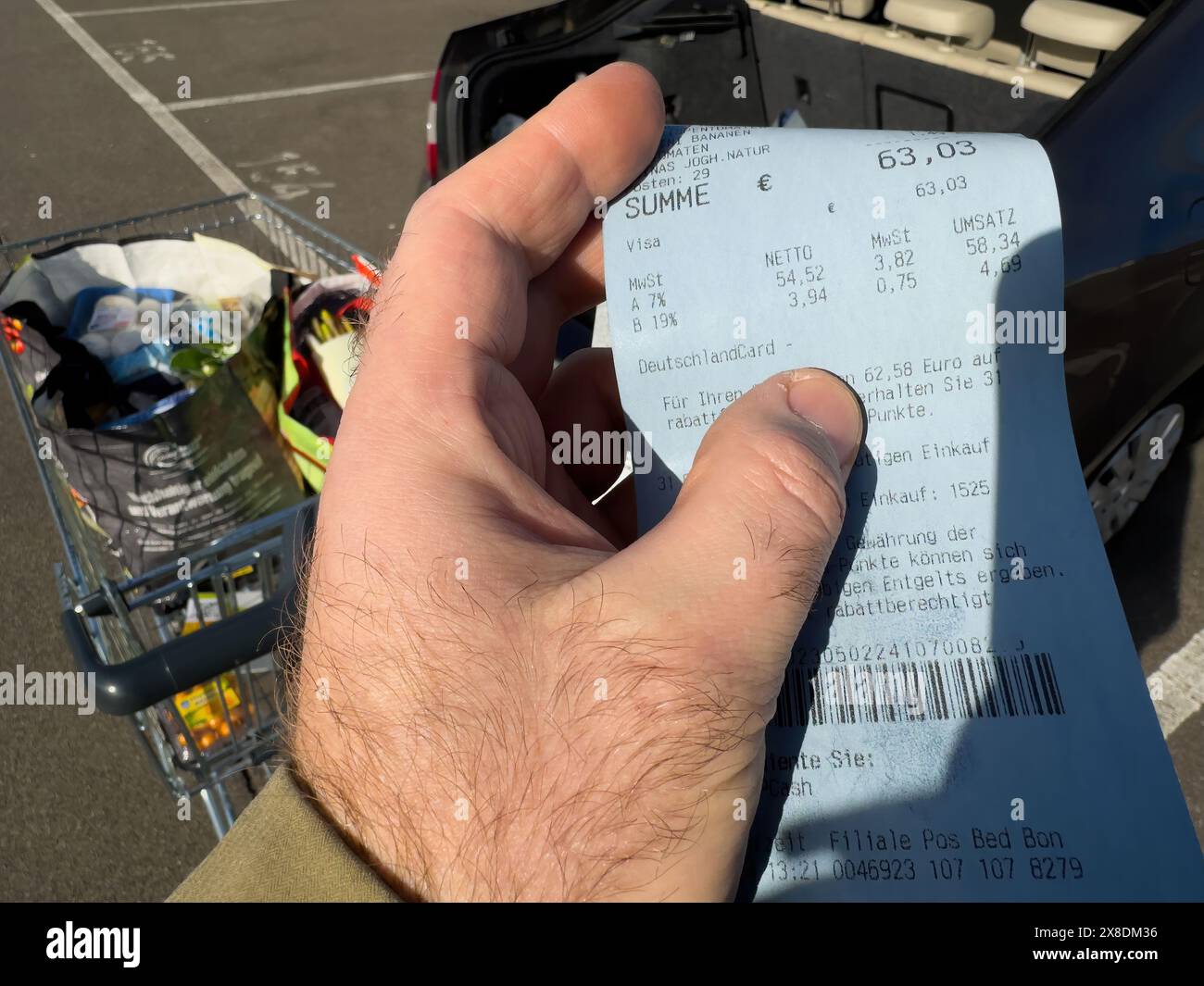 Freiburg, Germany - Feb 5, 2024: A person holding a shopping receipt in ...