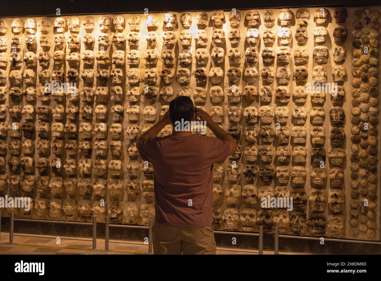 Mexico tourist taking a photo of an Aztec skull rack, or Tzompantli ...