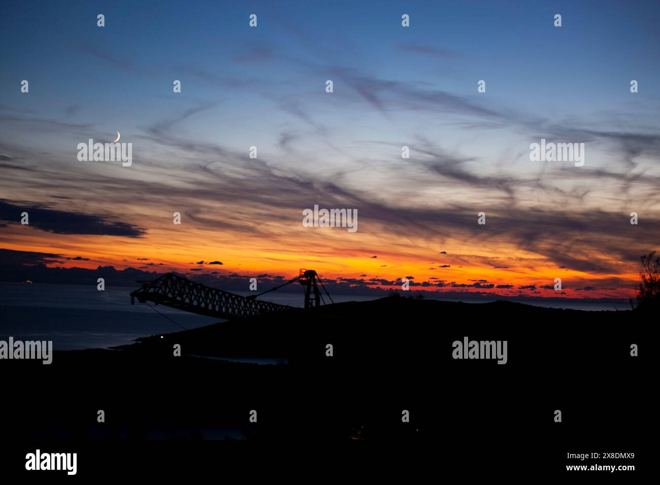Red-orange sky at sunset in twilight evening with dark clouds and moon ...