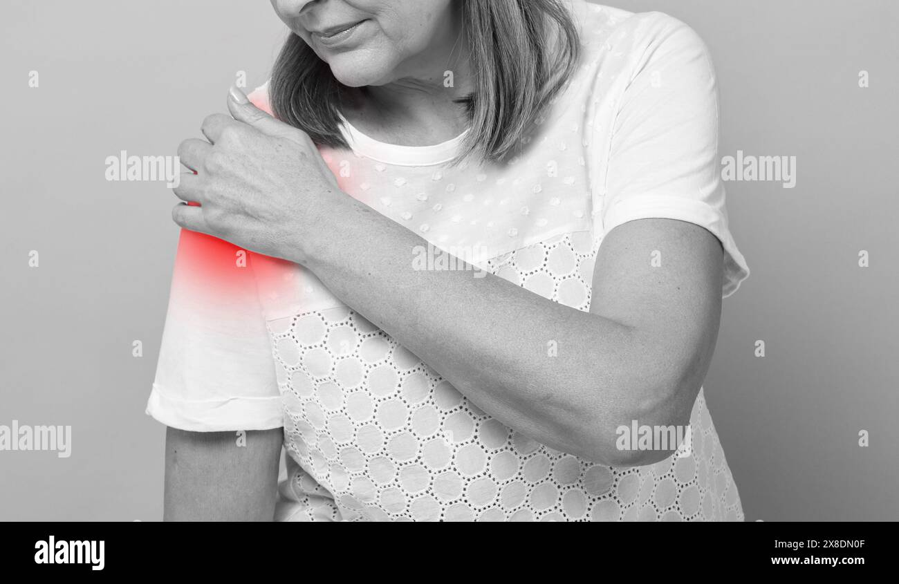 Woman suffering from pain in shoulder, closeup. Black and white effect ...