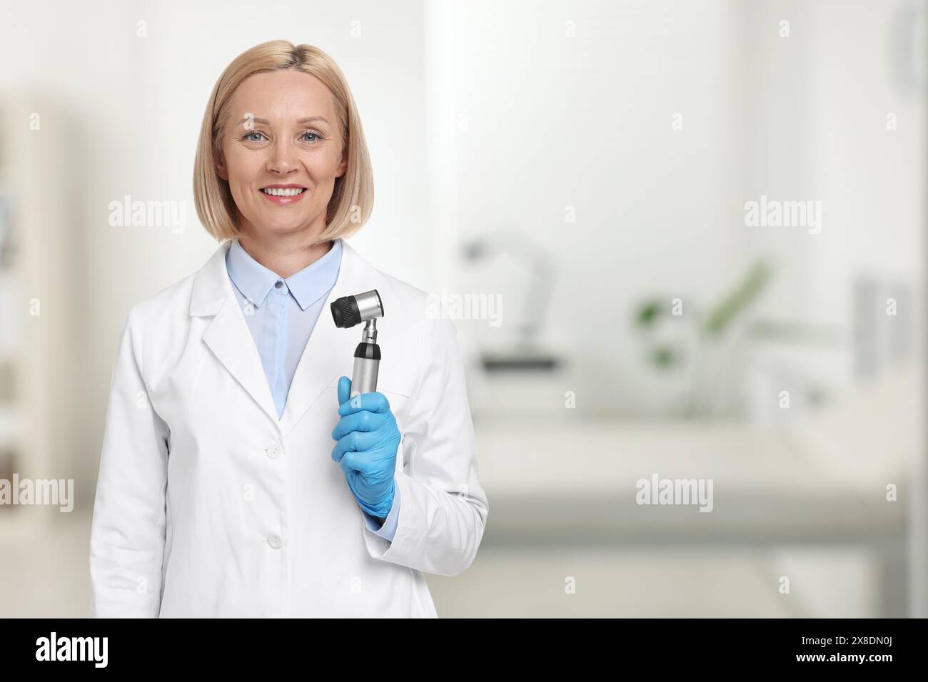 Professional dermatologist with dermatoscope on blurred background ...