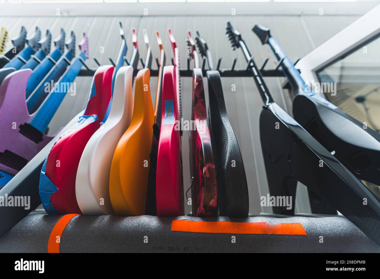 Closeup of row of different colorful bass guitars on the display ...