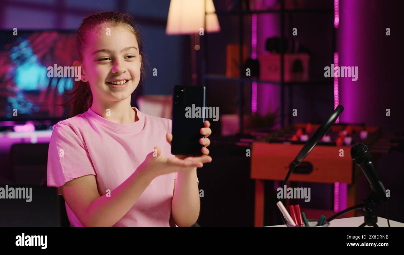 Joyous child influencer showcasing her most used apps on her smartphone ...