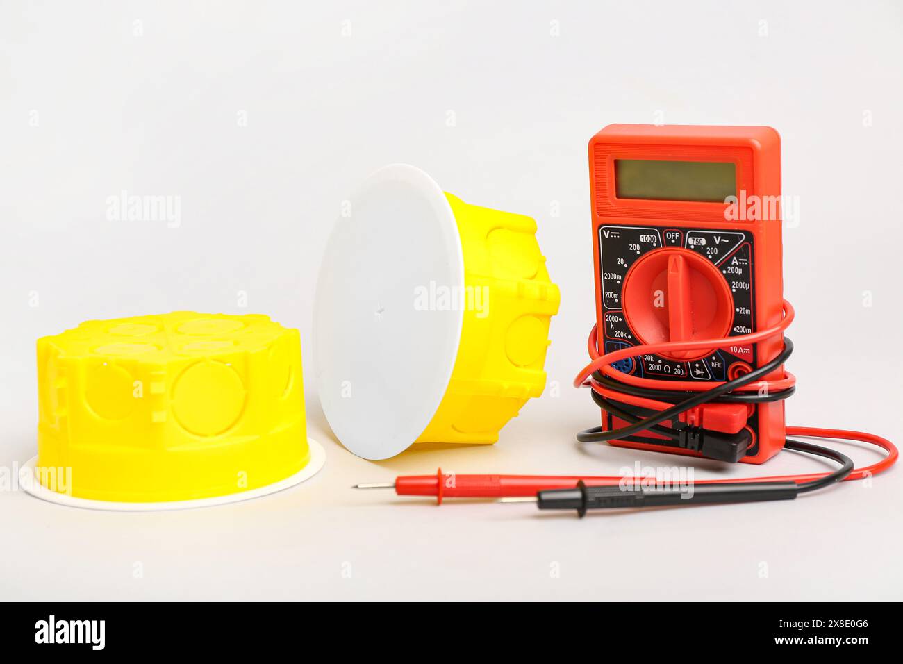 Multimeter and plastic mounting boxes on light background Stock Photo ...