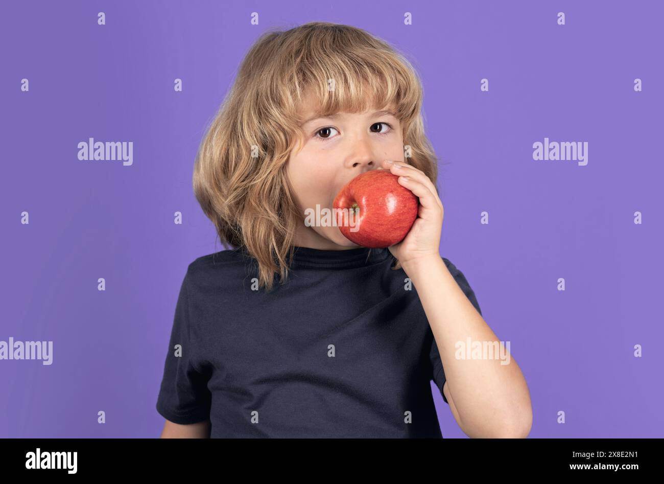 Kid eating an apple on isolated background. Healthy eating Stock Photo ...