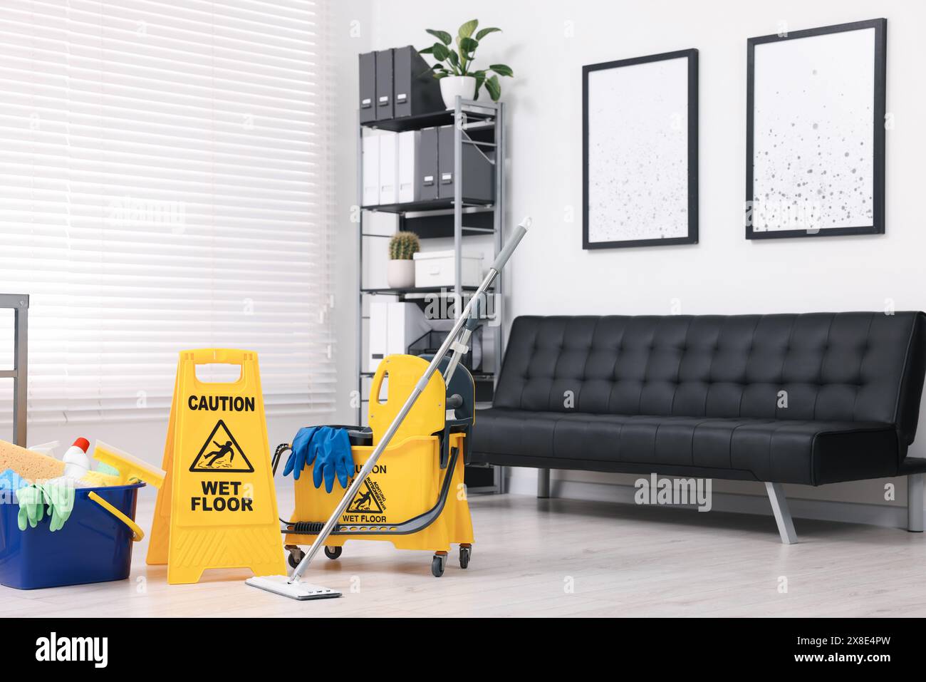 Cleaning service. Mop, wet floor sign and bucket with supplies in ...