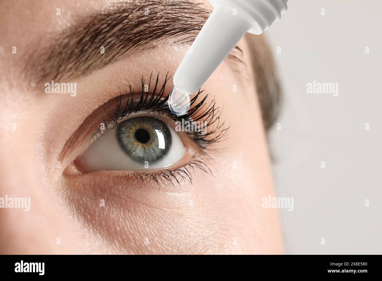Woman applying eye drops on light background, closeup Stock Photo - Alamy
