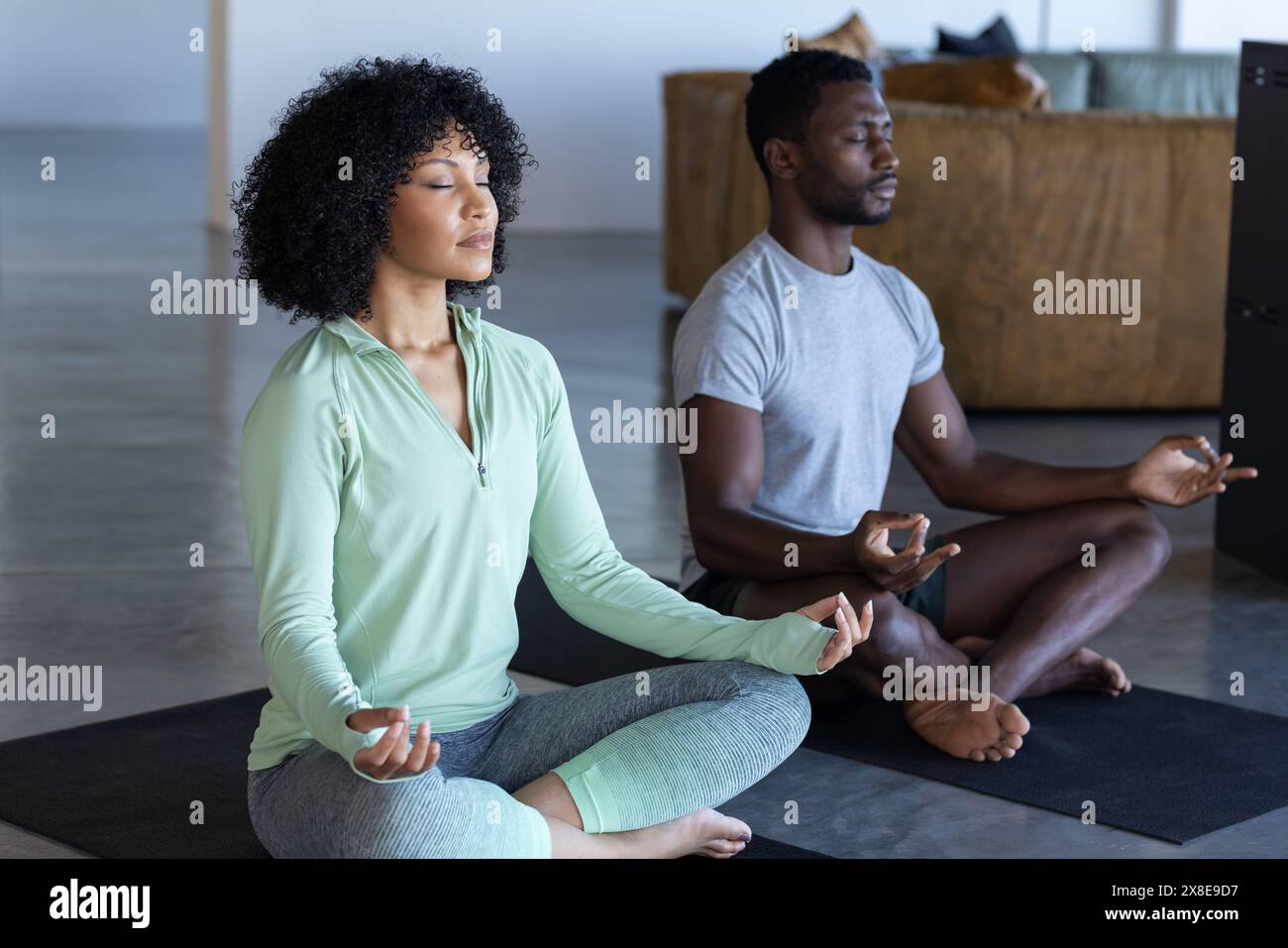 A diverse couple meditating together at home Stock Photo - Alamy