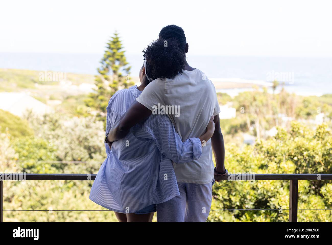 A diverse couple embracing outdoors, enjoying ocean view Stock Photo ...