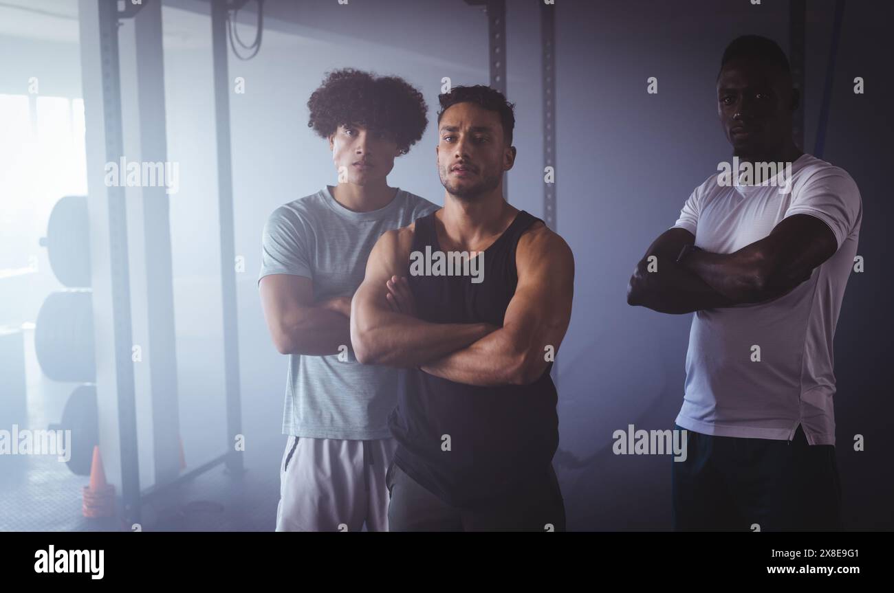 Three strong and fit young men standing confidently at gym with diverse ...