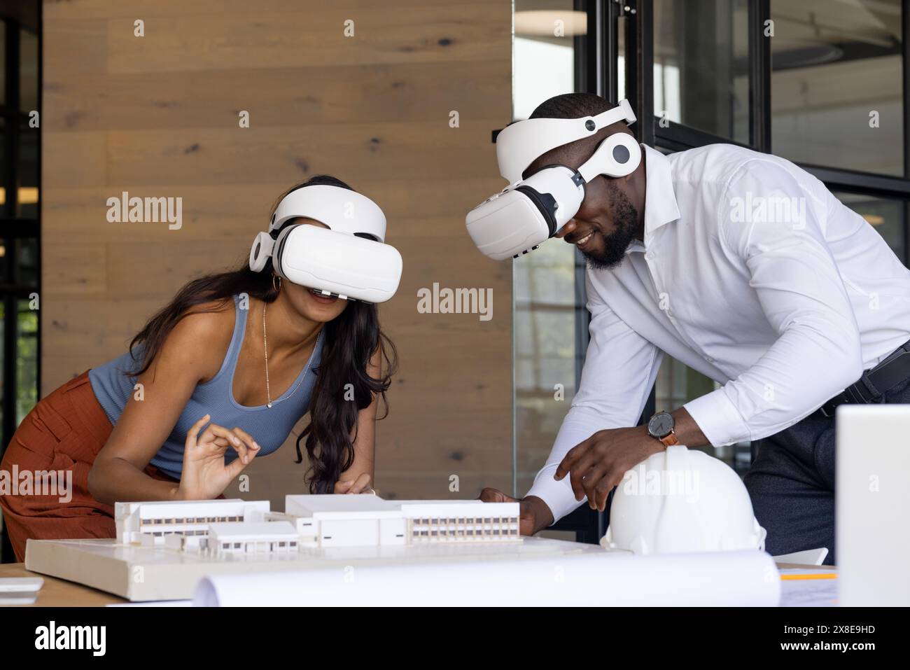 Diverse team of young colleagues using VR headsets for an architectural project. African ...