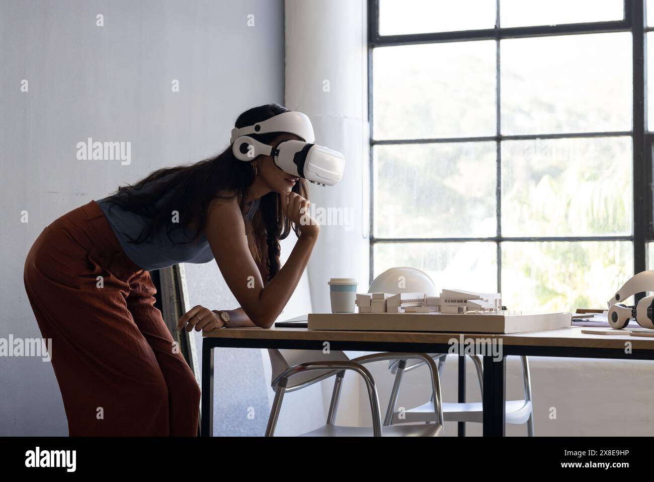 indian woman wearing virtual reality headset leaning over table in ...