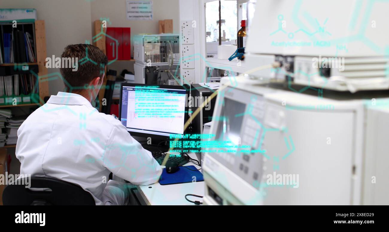 Caucasian male in white lab coat typing on computer in lab Stock Photo ...