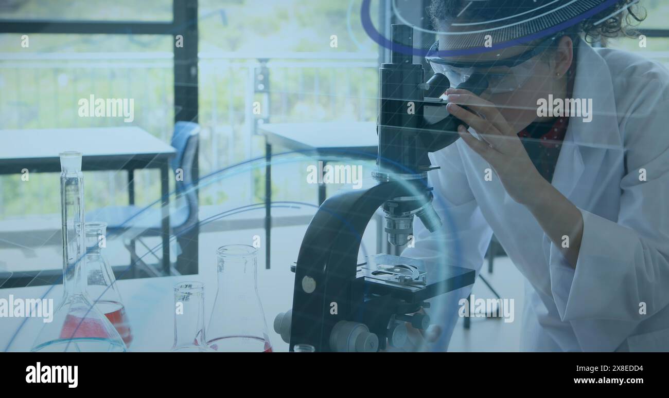Caucasian female scientist wearing lab coat, examining samples using a ...