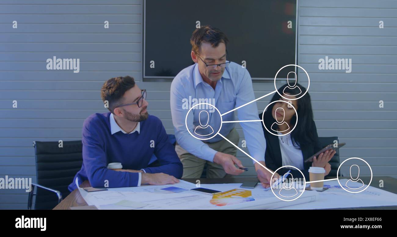 Diverse couple and Caucasian colleague reviewing documents at table ...